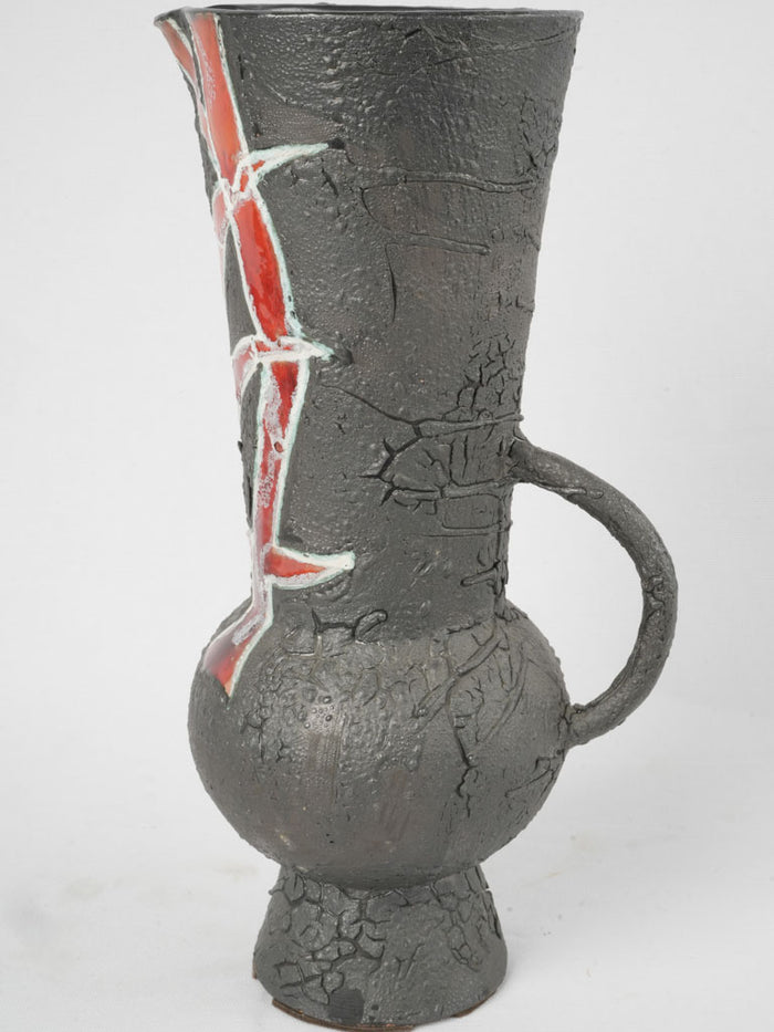 Large French volcanic black ceramic pitcher w/ red-glazed woodpecker d
