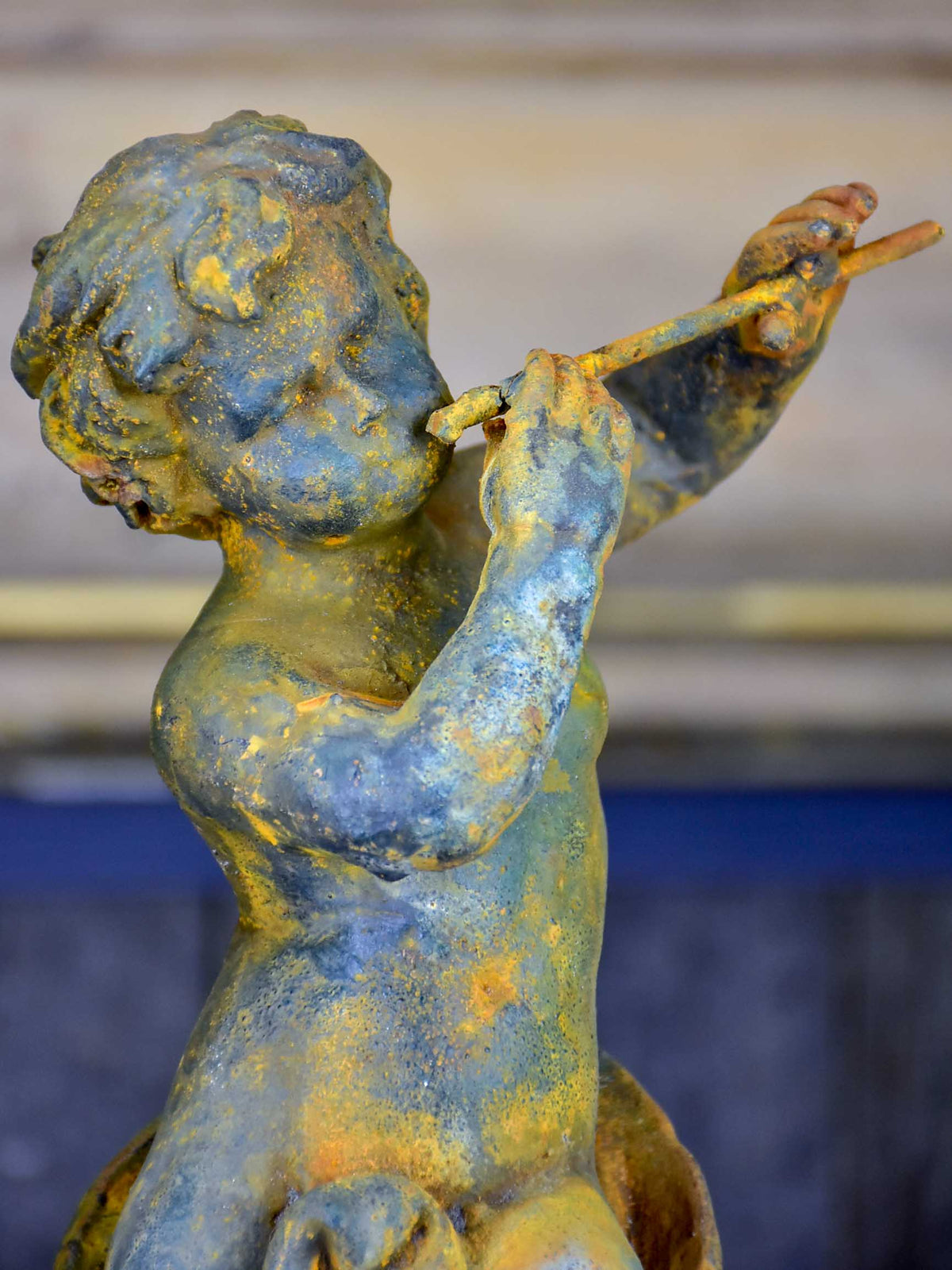 Two antique cast iron cherubs playing musical instruments