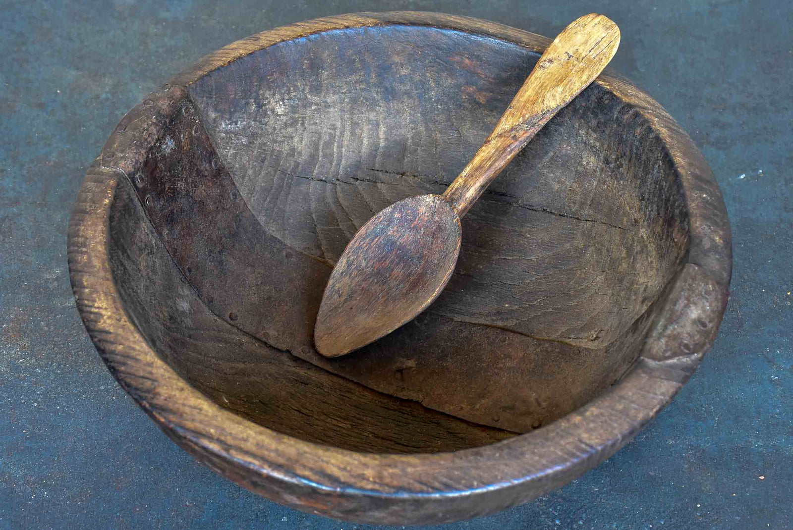 An antique French wooden bowl with repairs